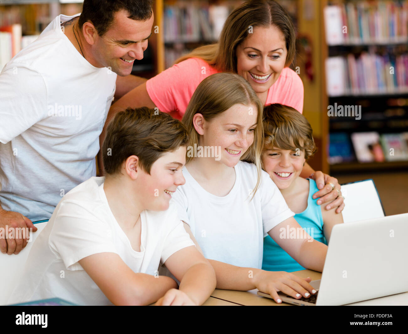 Family in library with books Stock Photo - Alamy
