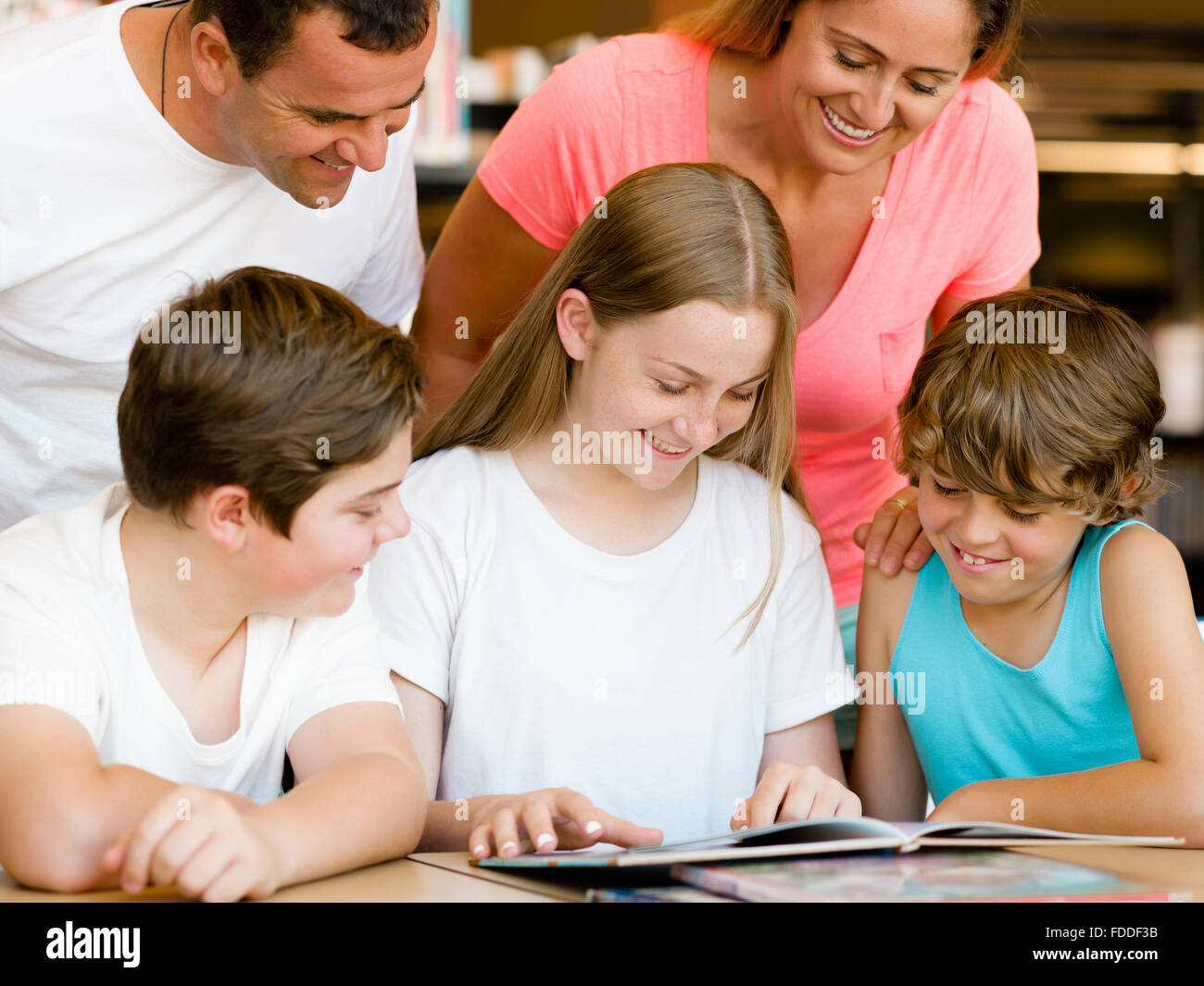 Family in library with books Stock Photo - Alamy