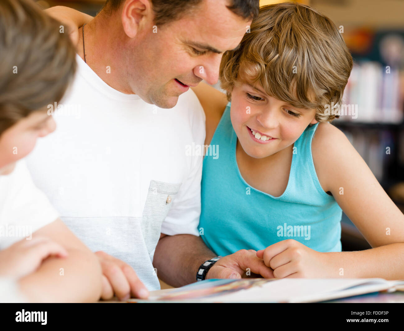 Father with sons in library with books Stock Photo - Alamy
