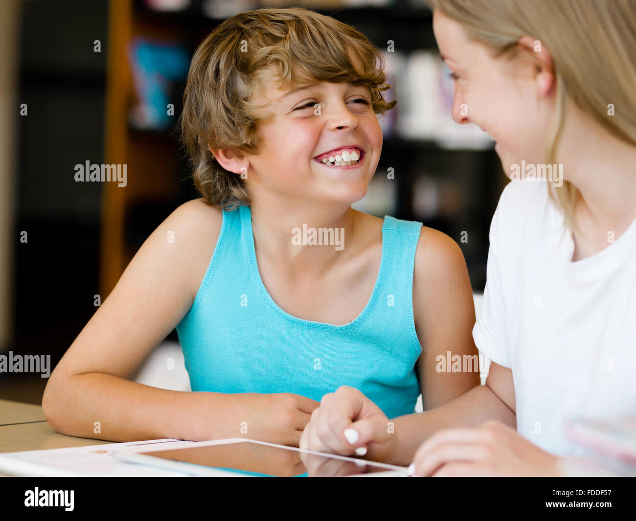 Teenage girl and her brother with books studying in library Stock Photo ...