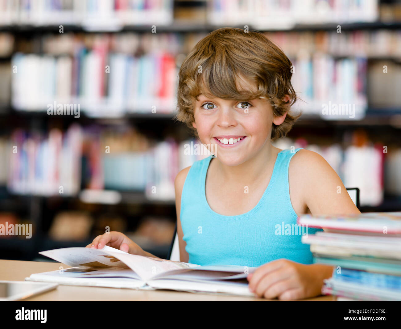 Boy in library with books Stock Photo - Alamy