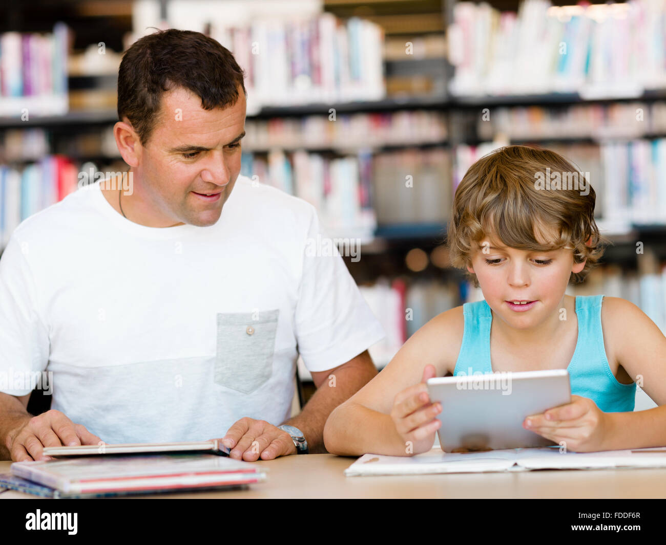 Little boy and his father with computer in library Stock Photo - Alamy