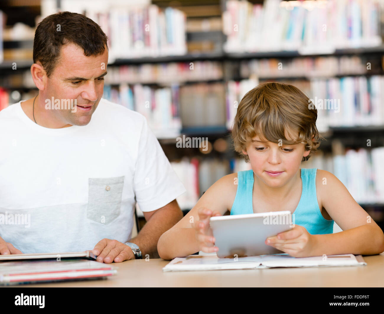 Little boy and his father with computer in library Stock Photo - Alamy