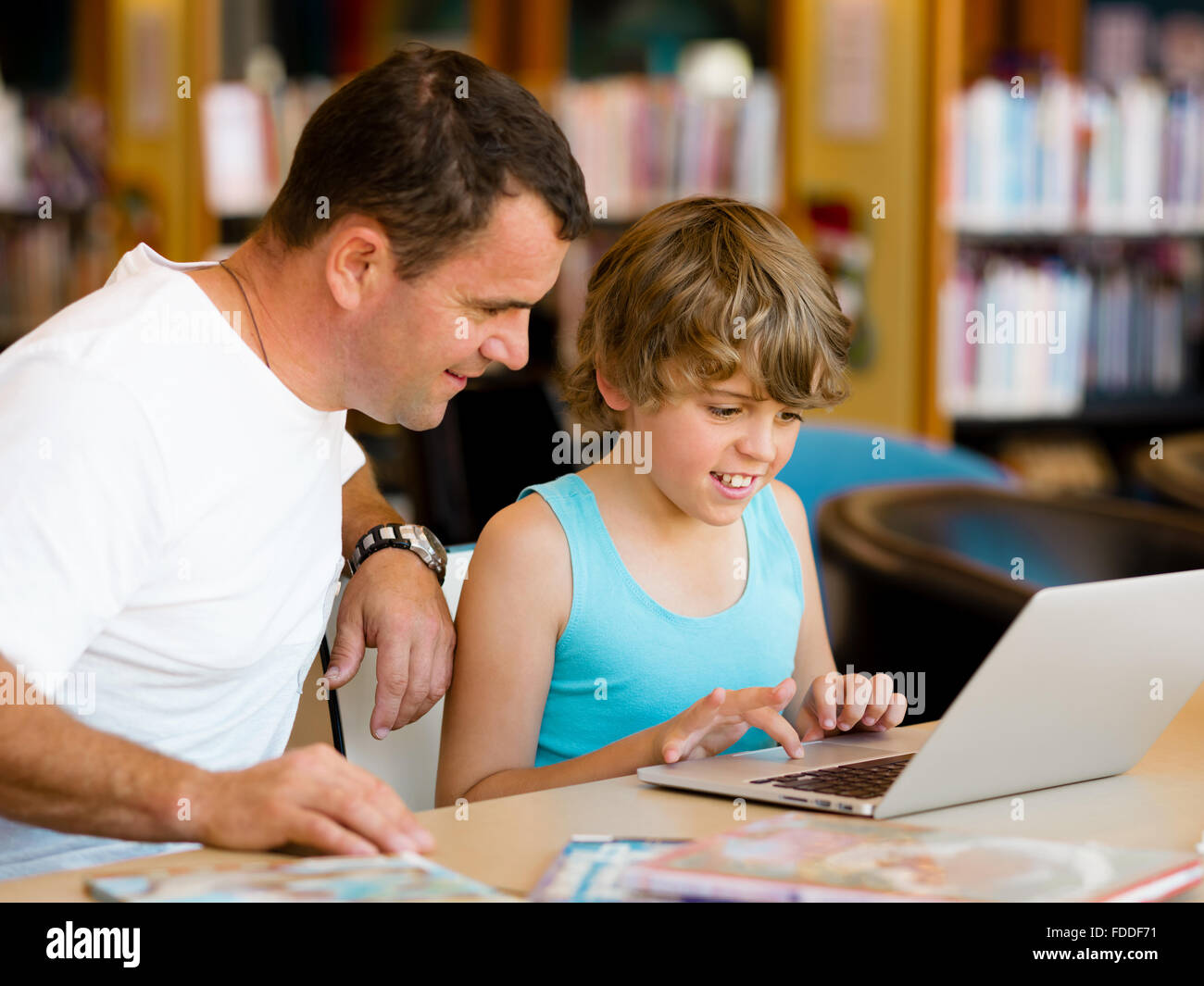 Little boy and his father with laptop in library Stock Photo - Alamy
