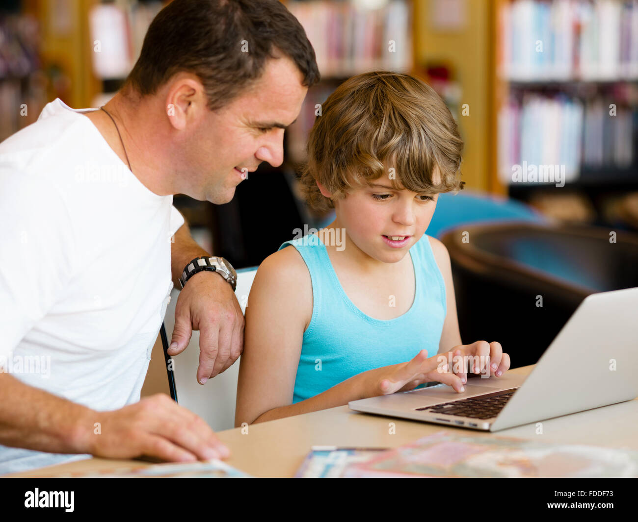 Little boy and his father with laptop in library Stock Photo - Alamy