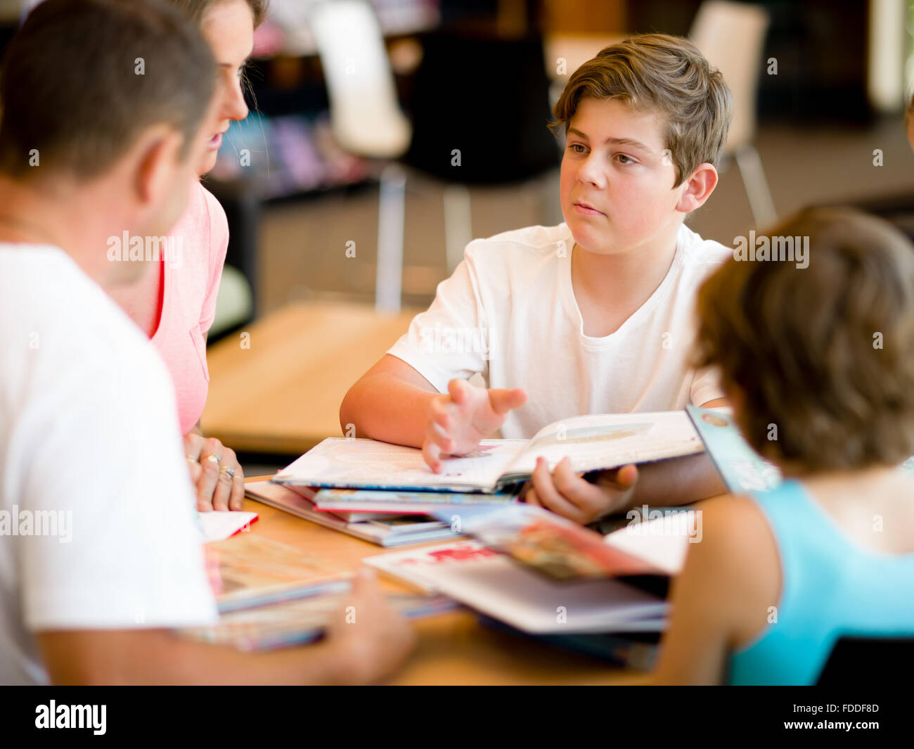 Family in library with books Stock Photo - Alamy