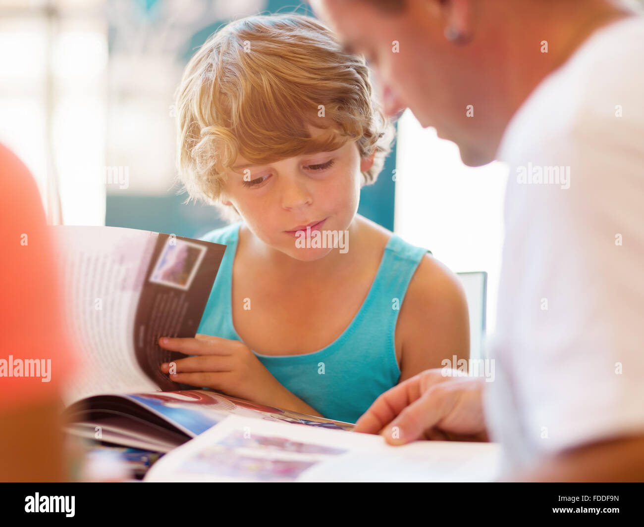 Boy and his father in library with books Stock Photo - Alamy