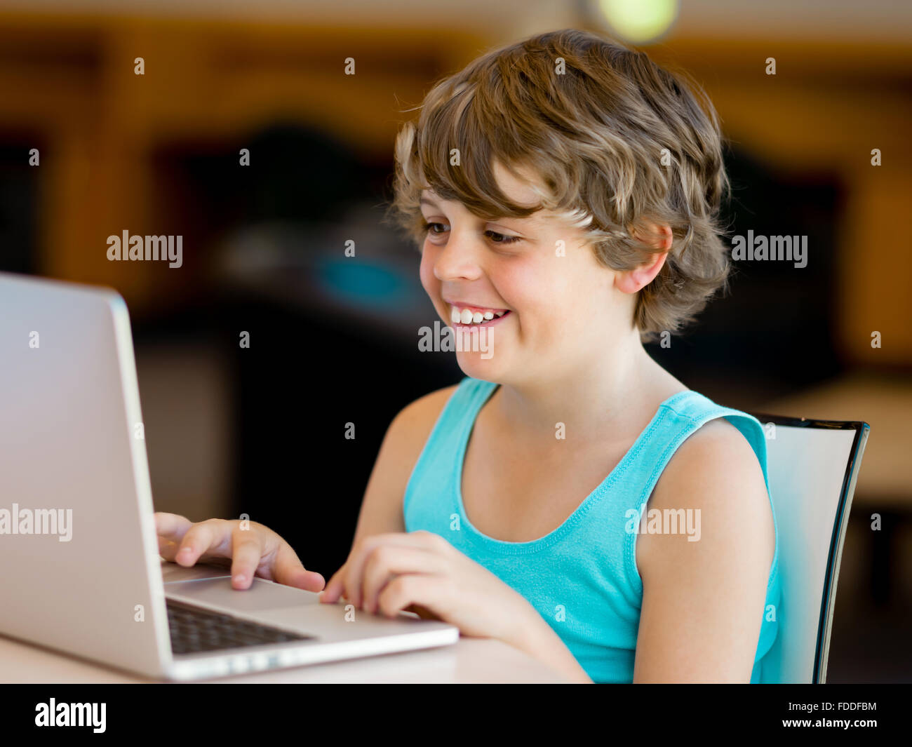 Little boy with laptop in library Stock Photo - Alamy