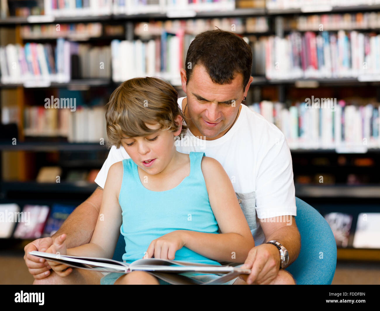 Father with son in library with books Stock Photo - Alamy