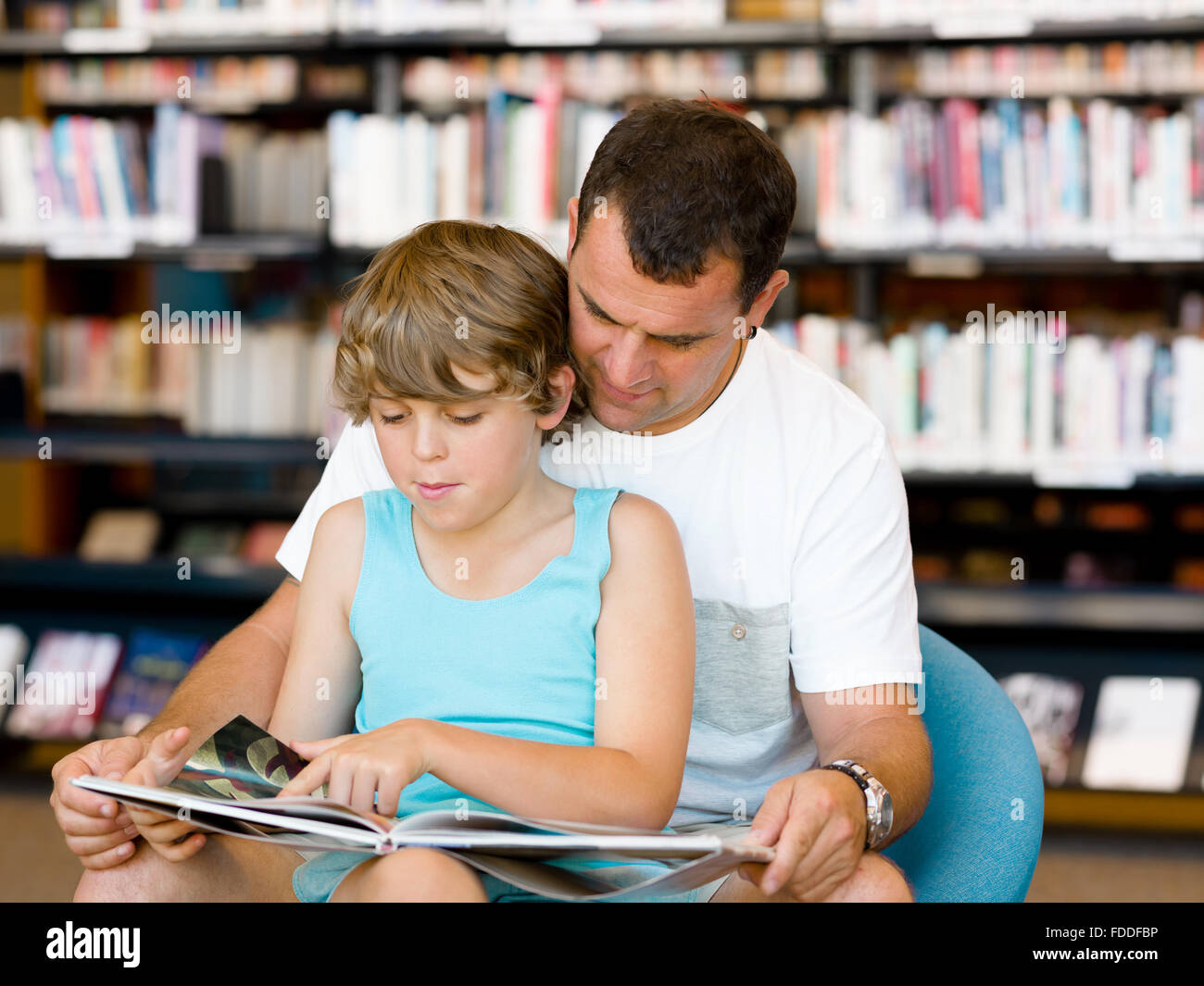 Father with son in library with books Stock Photo - Alamy