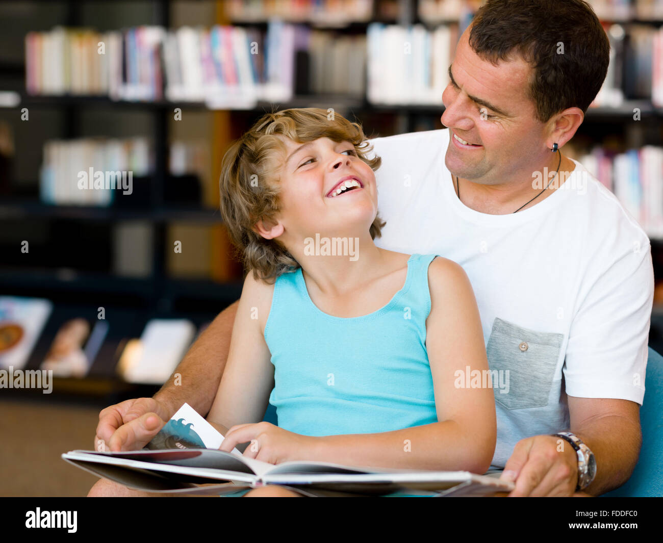 Father with son in library with books Stock Photo - Alamy