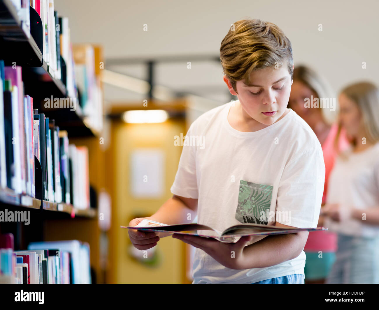 Boy in library choosing books Stock Photo - Alamy