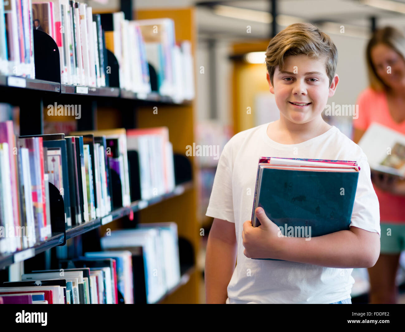 Boy in library choosing books Stock Photo - Alamy