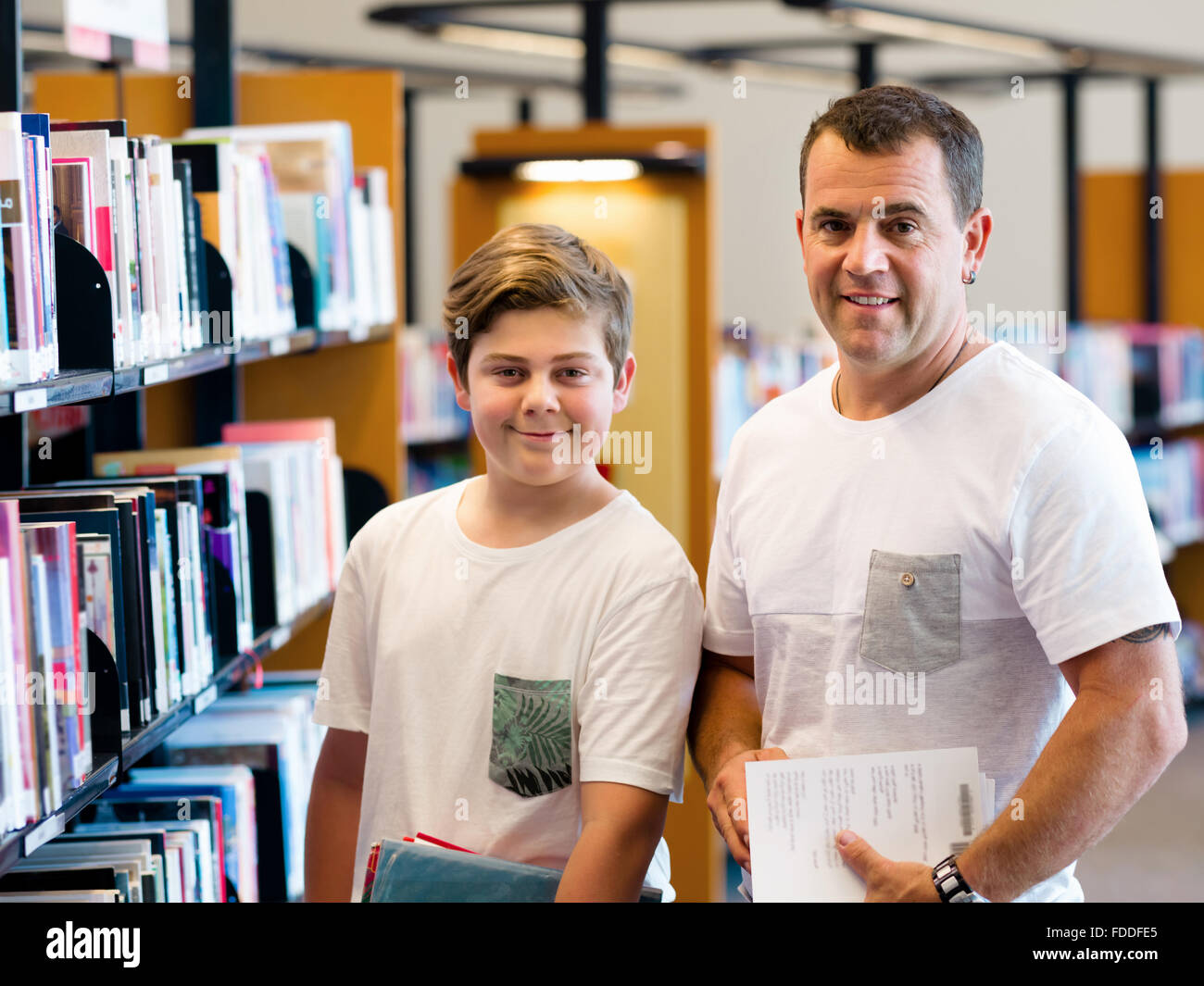 Boy and his father in library choosing books Stock Photo - Alamy