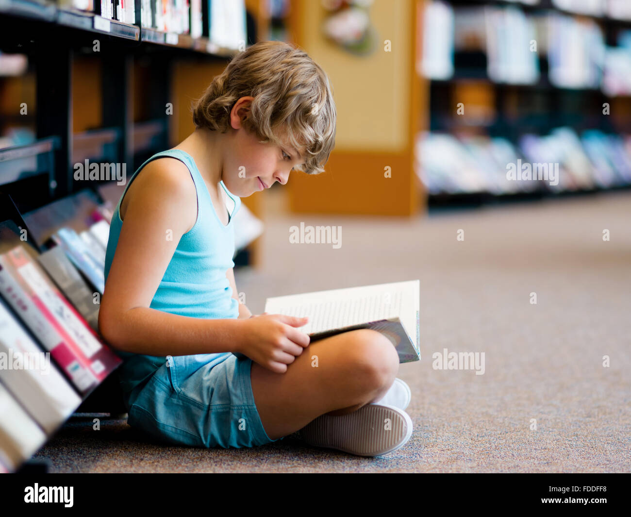 Boy in library with books Stock Photo - Alamy