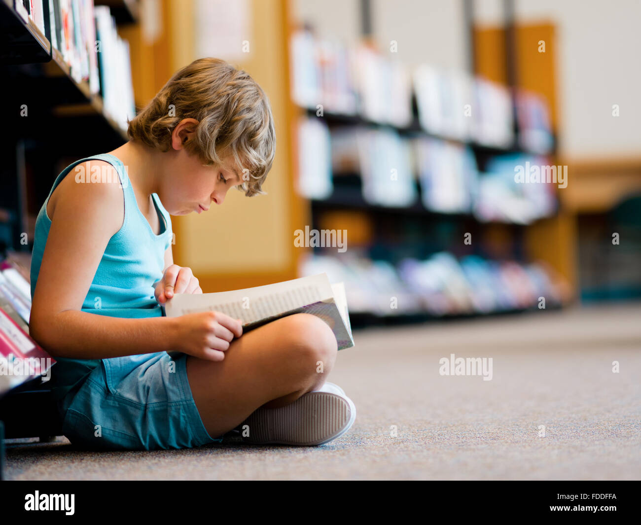 Boy in library with books Stock Photo - Alamy
