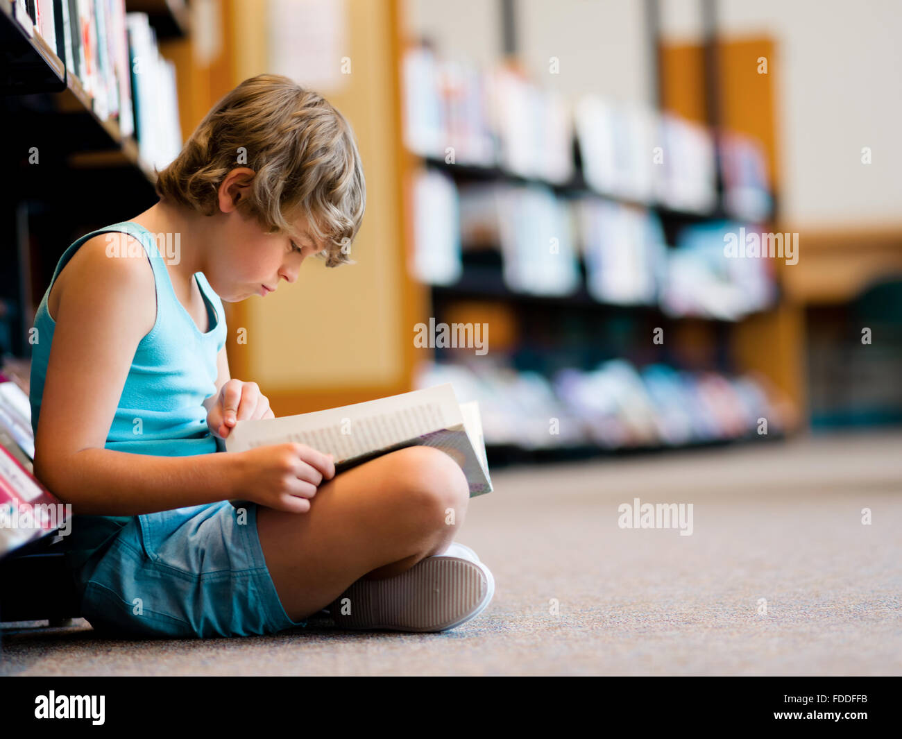 Boy in library with books Stock Photo - Alamy