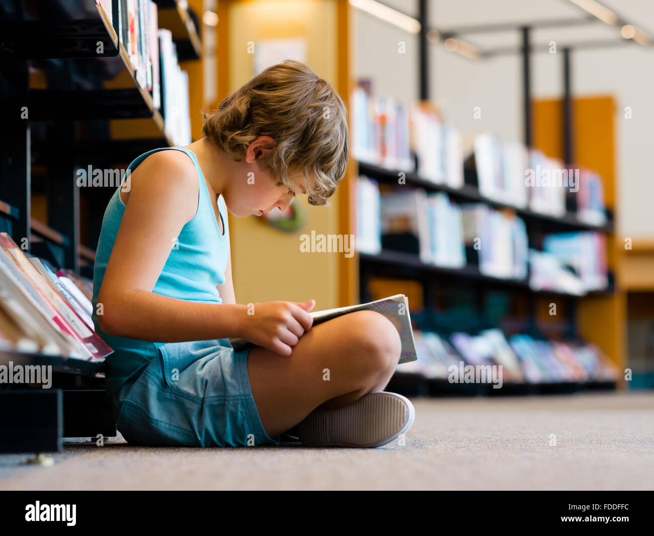 Boy in library with books Stock Photo - Alamy