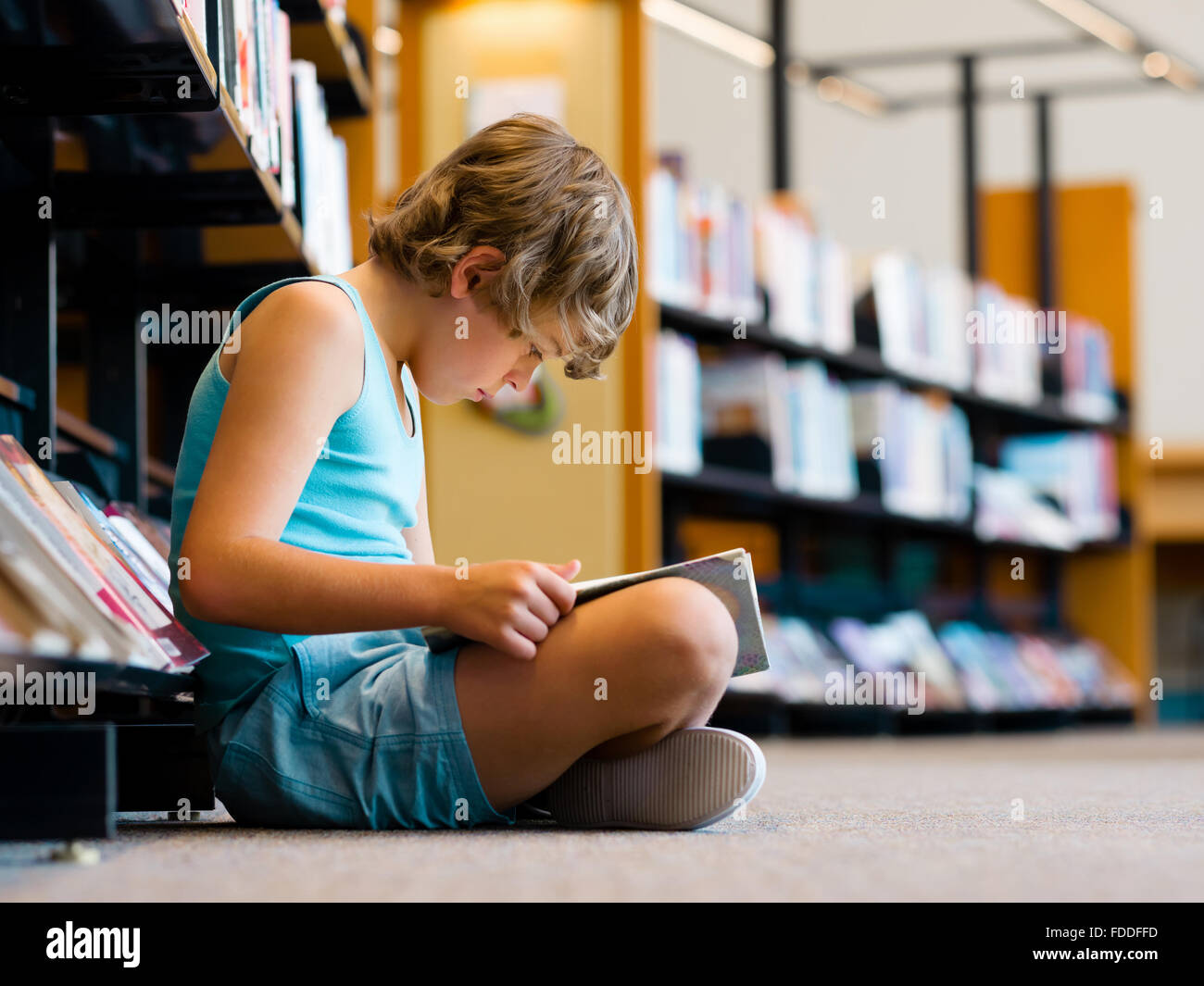 Boy in library with books Stock Photo - Alamy