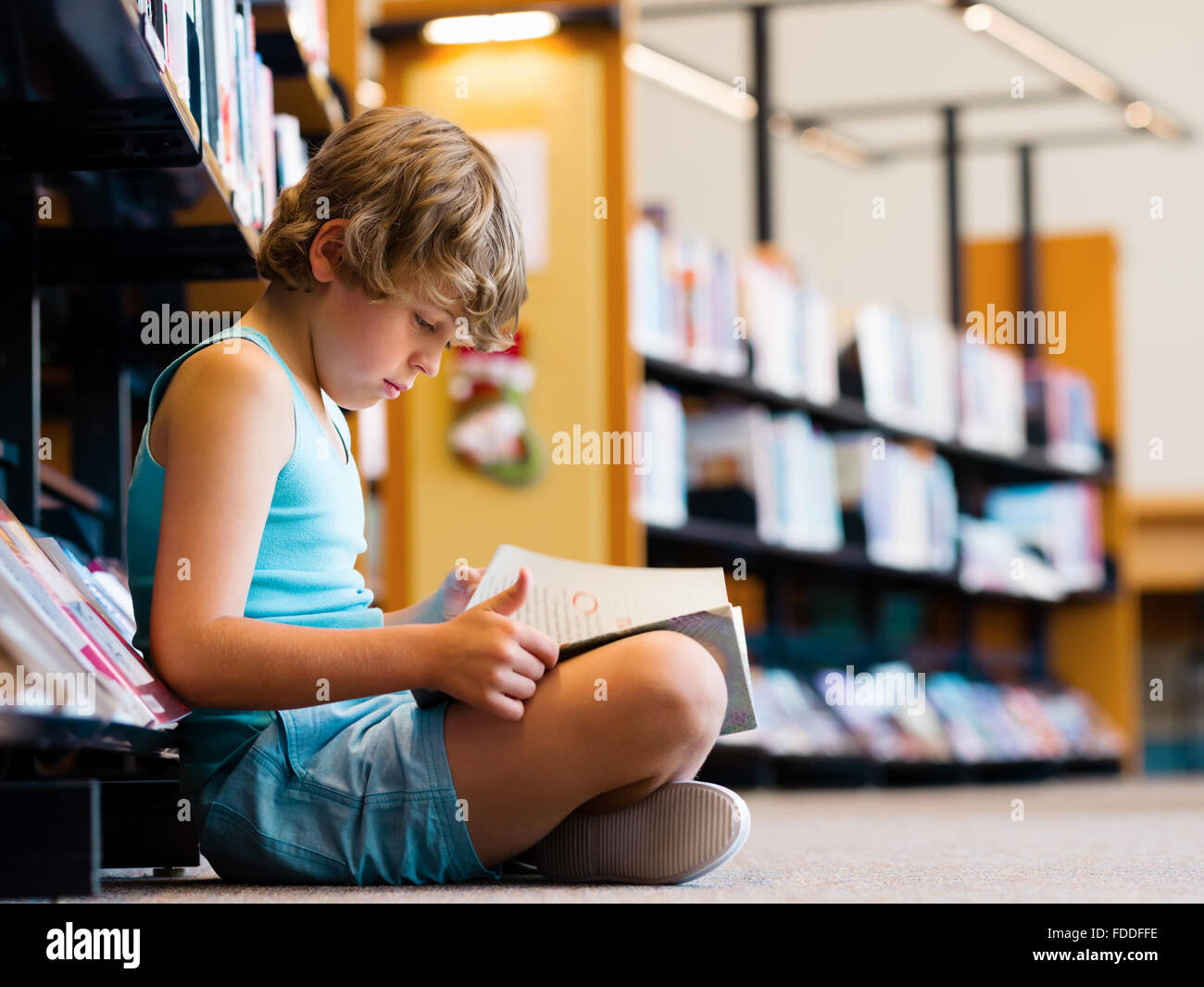 Boy in library with books Stock Photo - Alamy