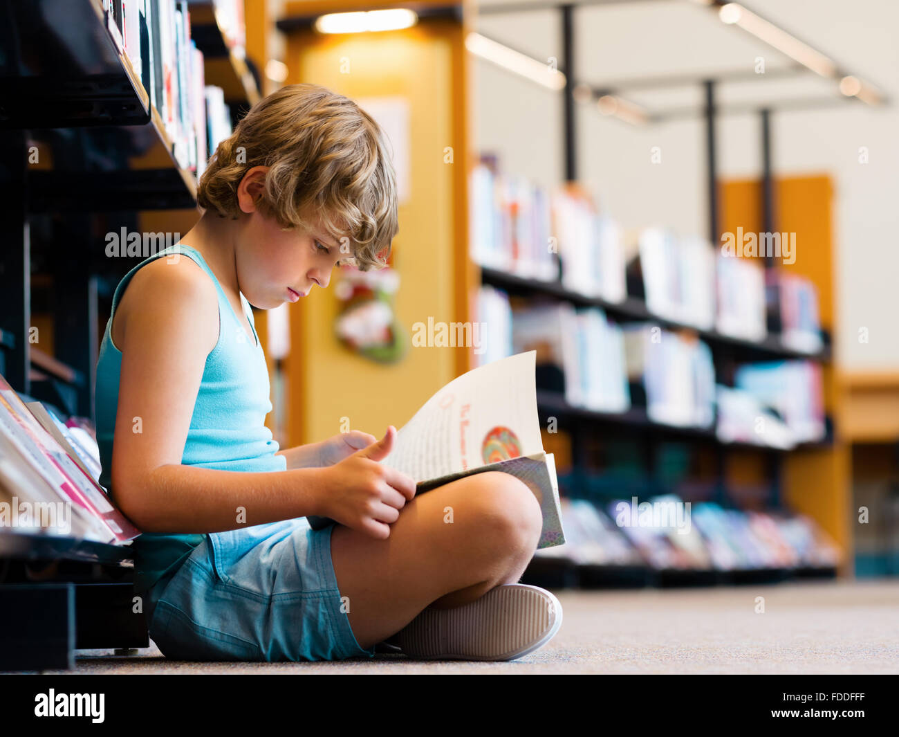 Boy in library with books Stock Photo - Alamy