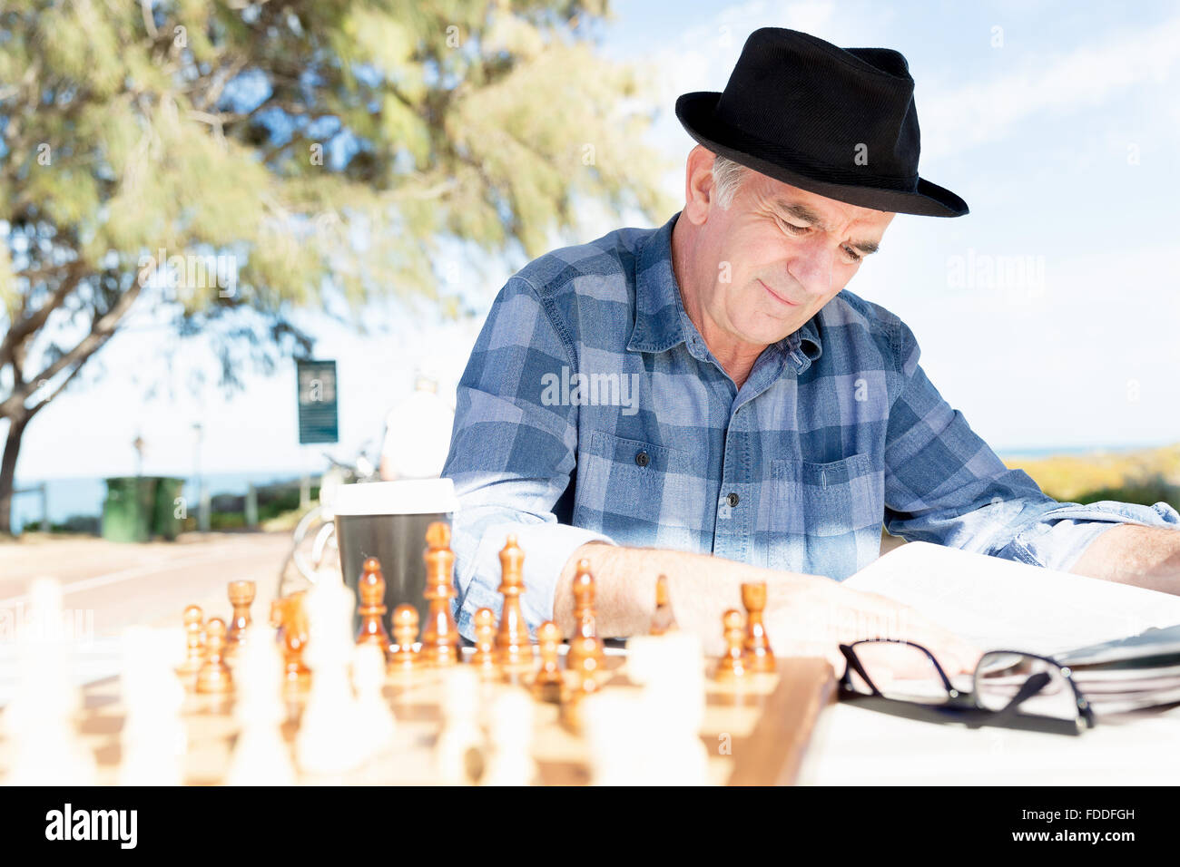 Senior gentleman reading newspaper in park Stock Photo - Alamy