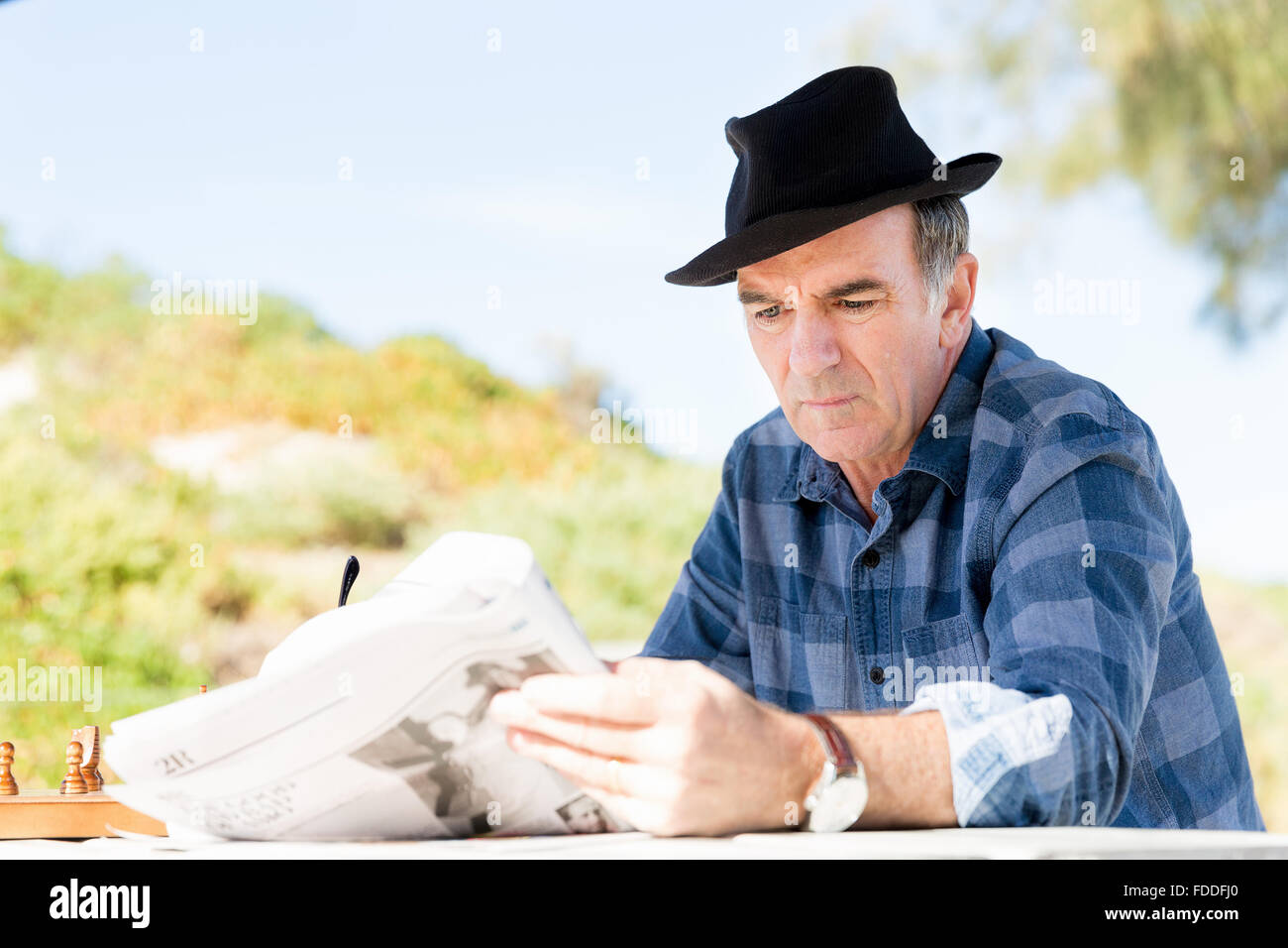 Senior gentleman reading newspaper in park Stock Photo - Alamy