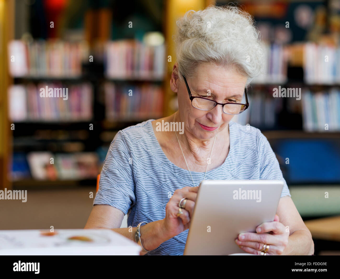Elderly lady working with tablet Stock Photo - Alamy