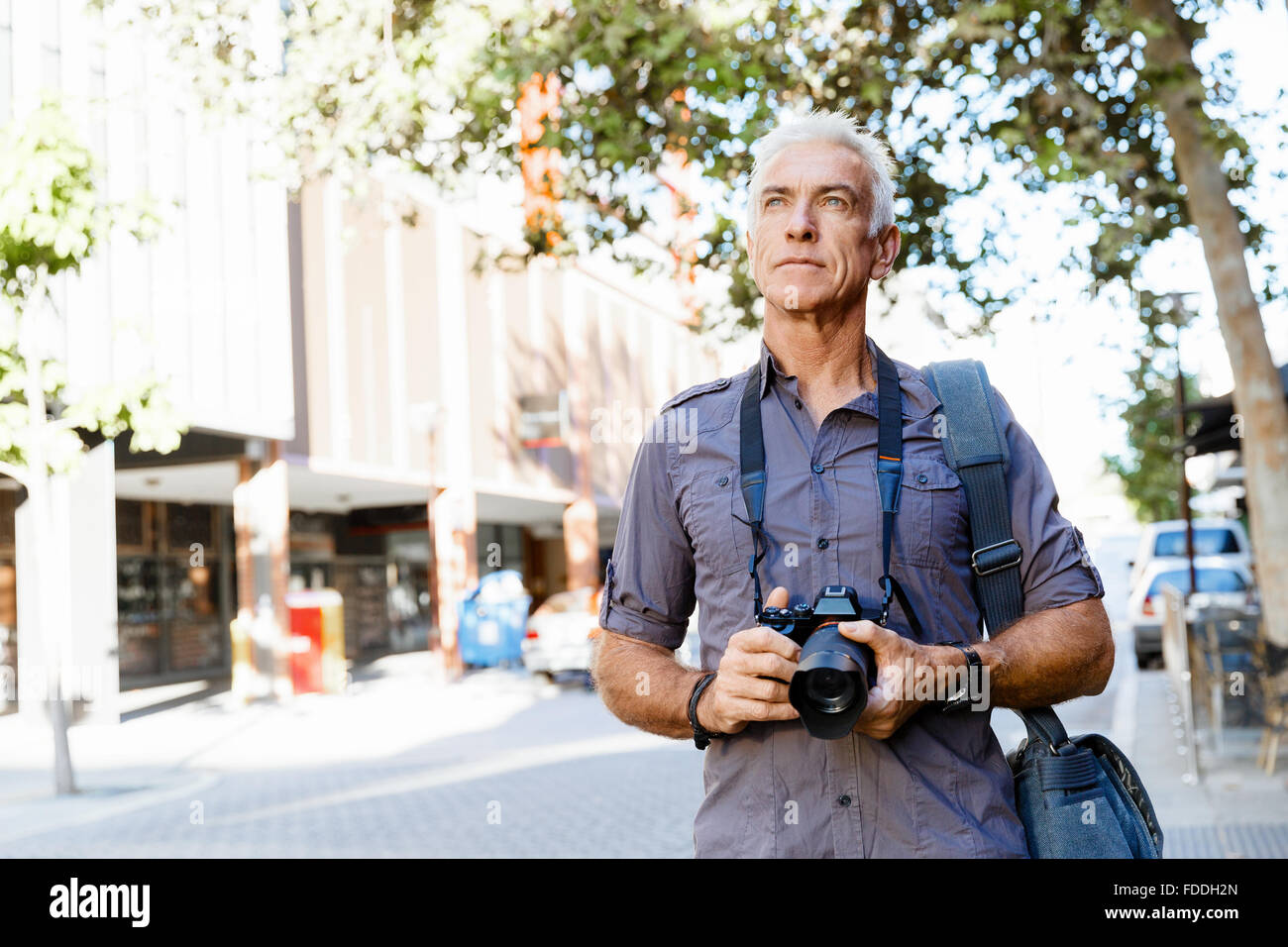 Senior man with camera in city Stock Photo - Alamy