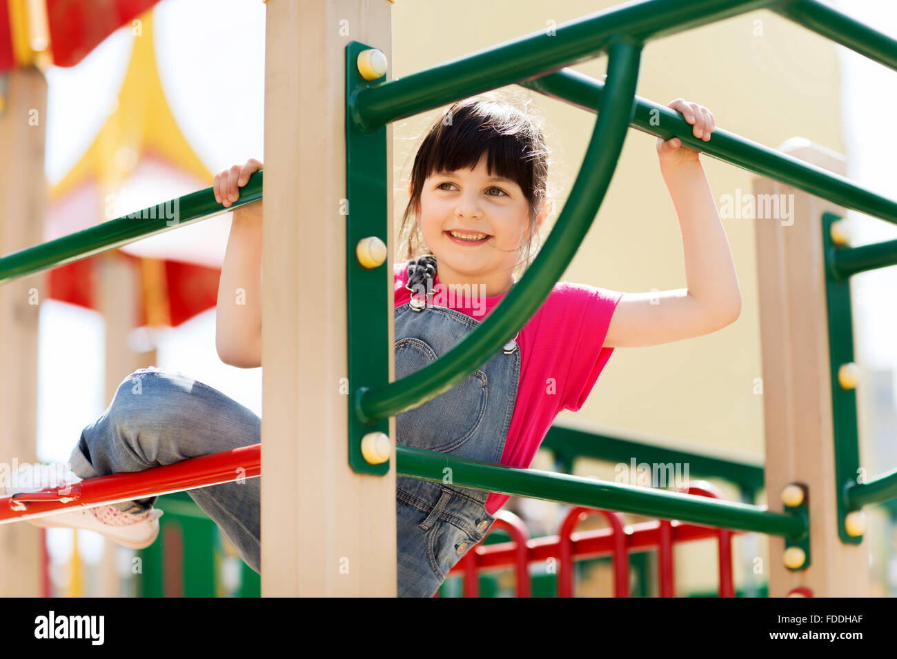 happy little girl climbing on children playground Stock Photo - Alamy