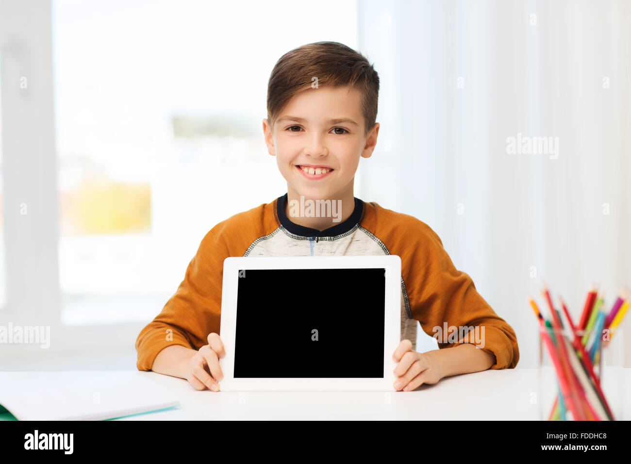 smiling boy showing tablet pc blank screen at home Stock Photo - Alamy
