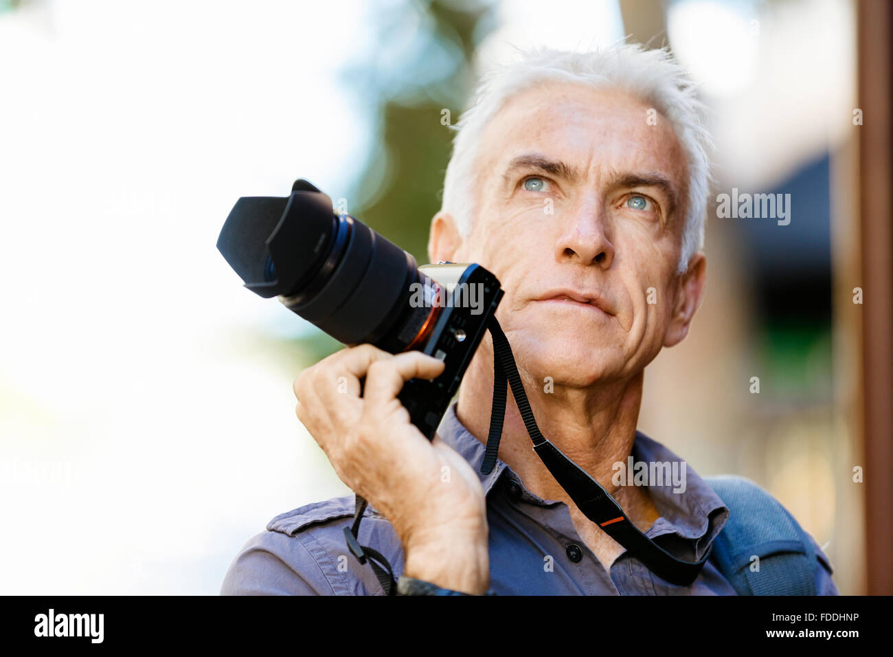 Senior man with camera in city Stock Photo - Alamy