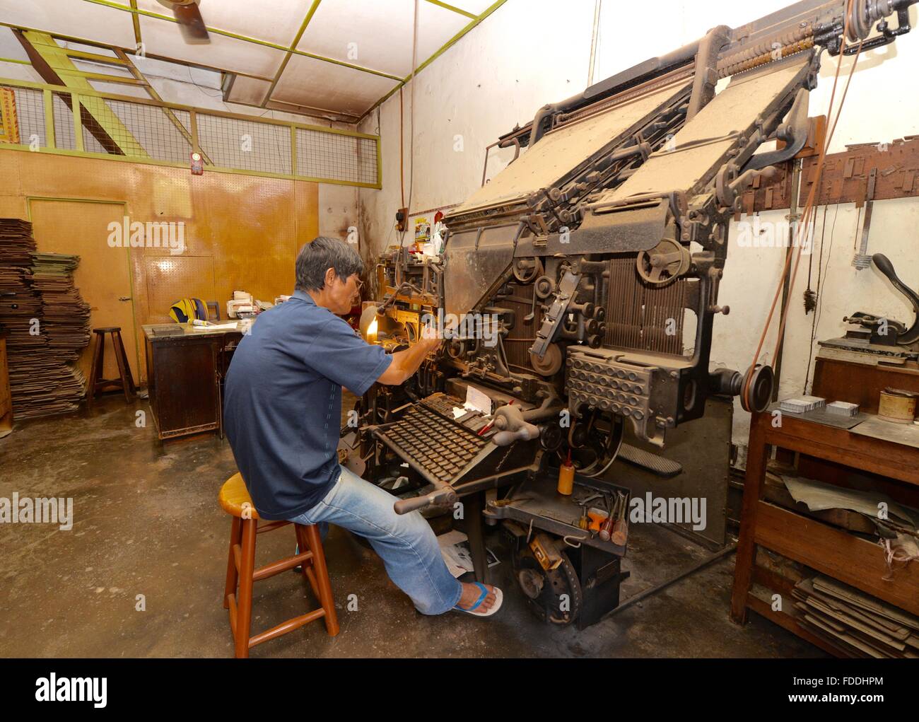 Man working on old printing press, Chinatown Melaka Stock Photo - Alamy