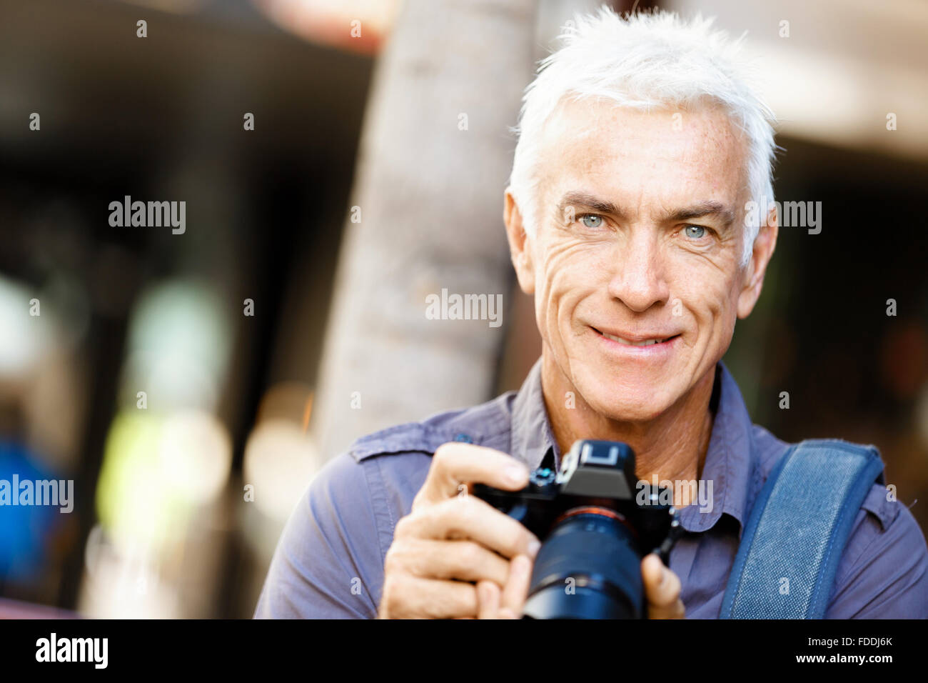 Senior man with camera in city Stock Photo - Alamy