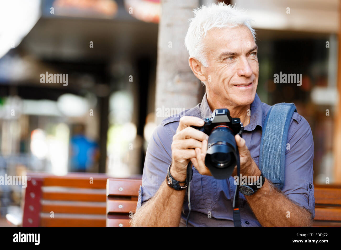 Senior man with camera in city Stock Photo - Alamy