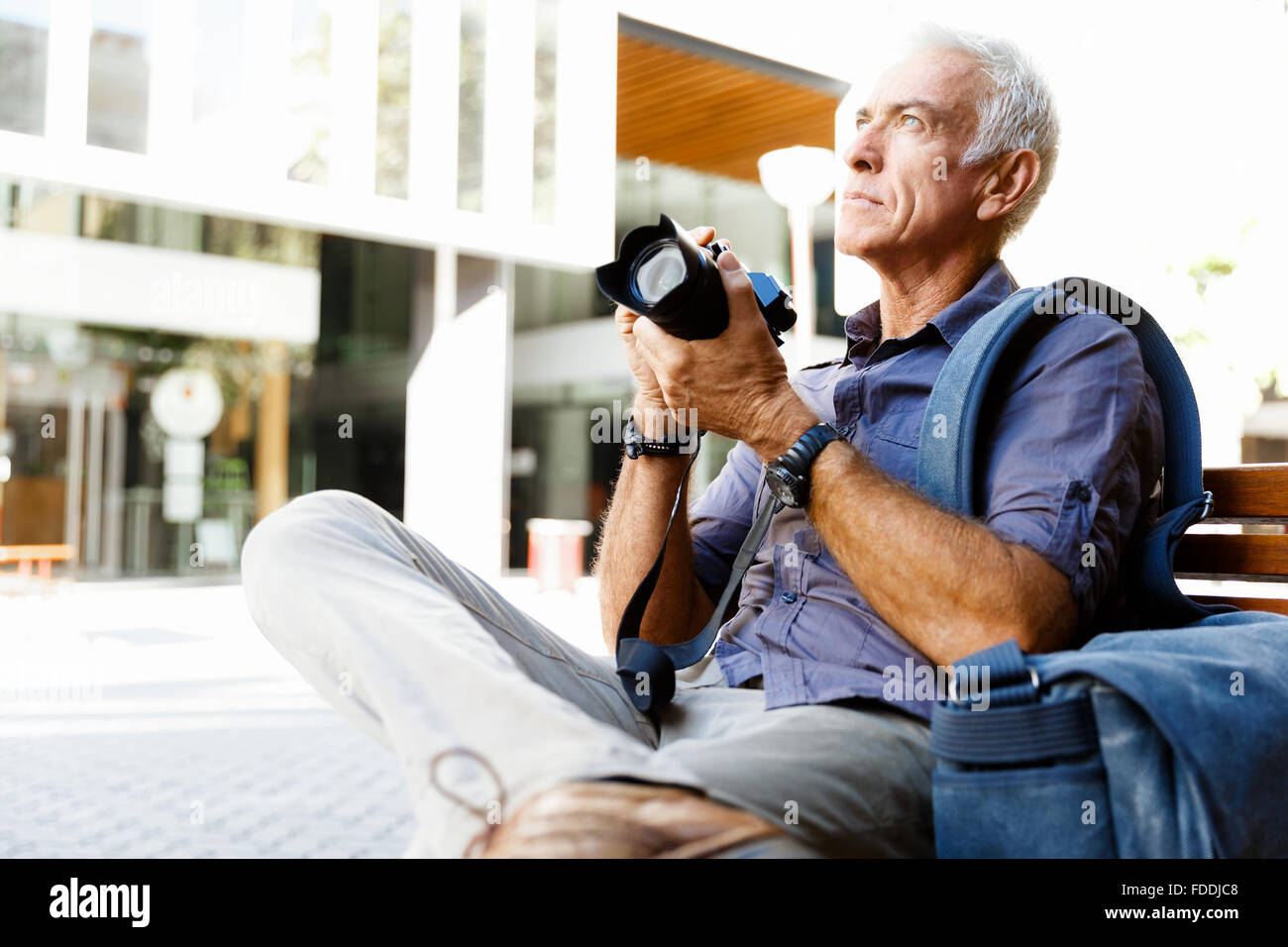 Senior man with camera in city Stock Photo - Alamy