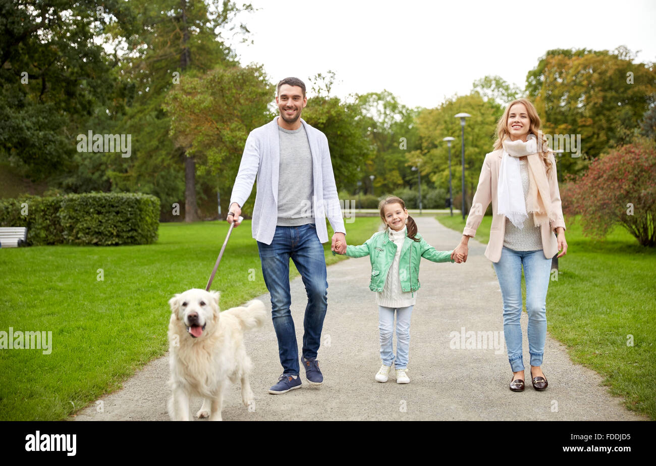 happy family with labrador retriever dog in park Stock Photo - Alamy