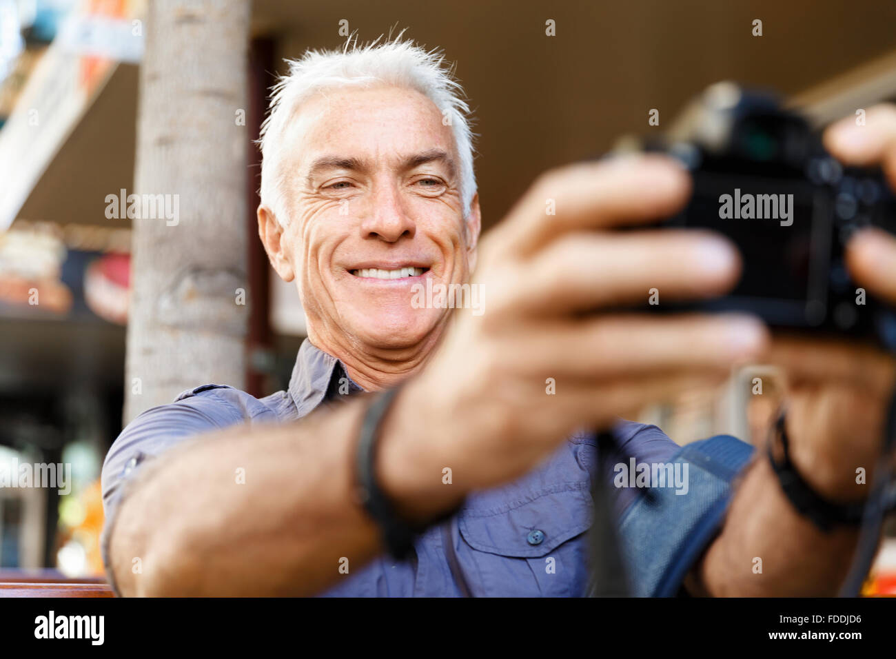 Senior man with camera in city Stock Photo - Alamy