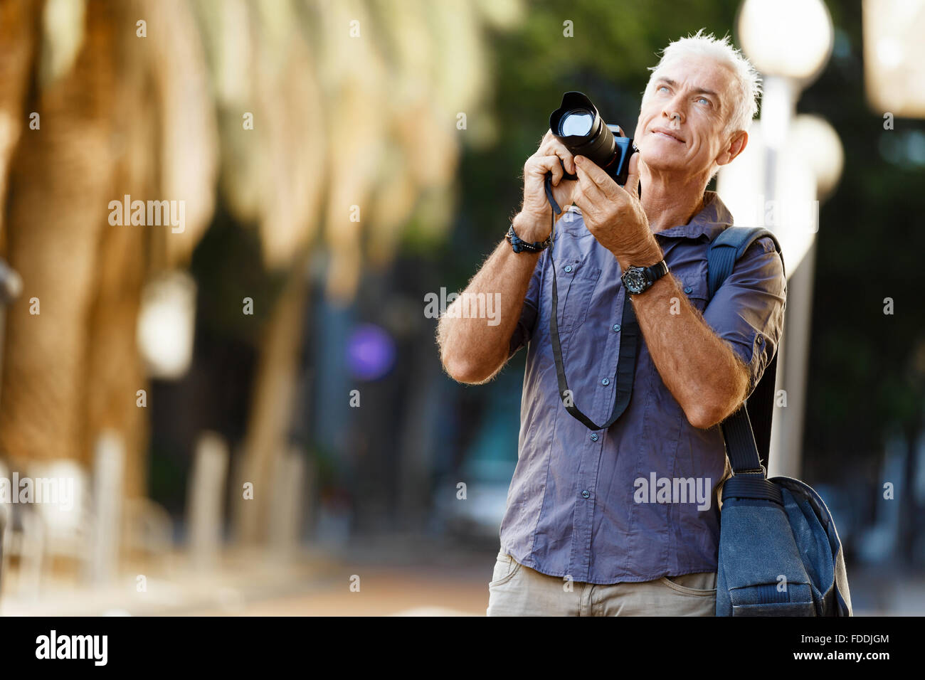 Senior man with camera in city Stock Photo - Alamy