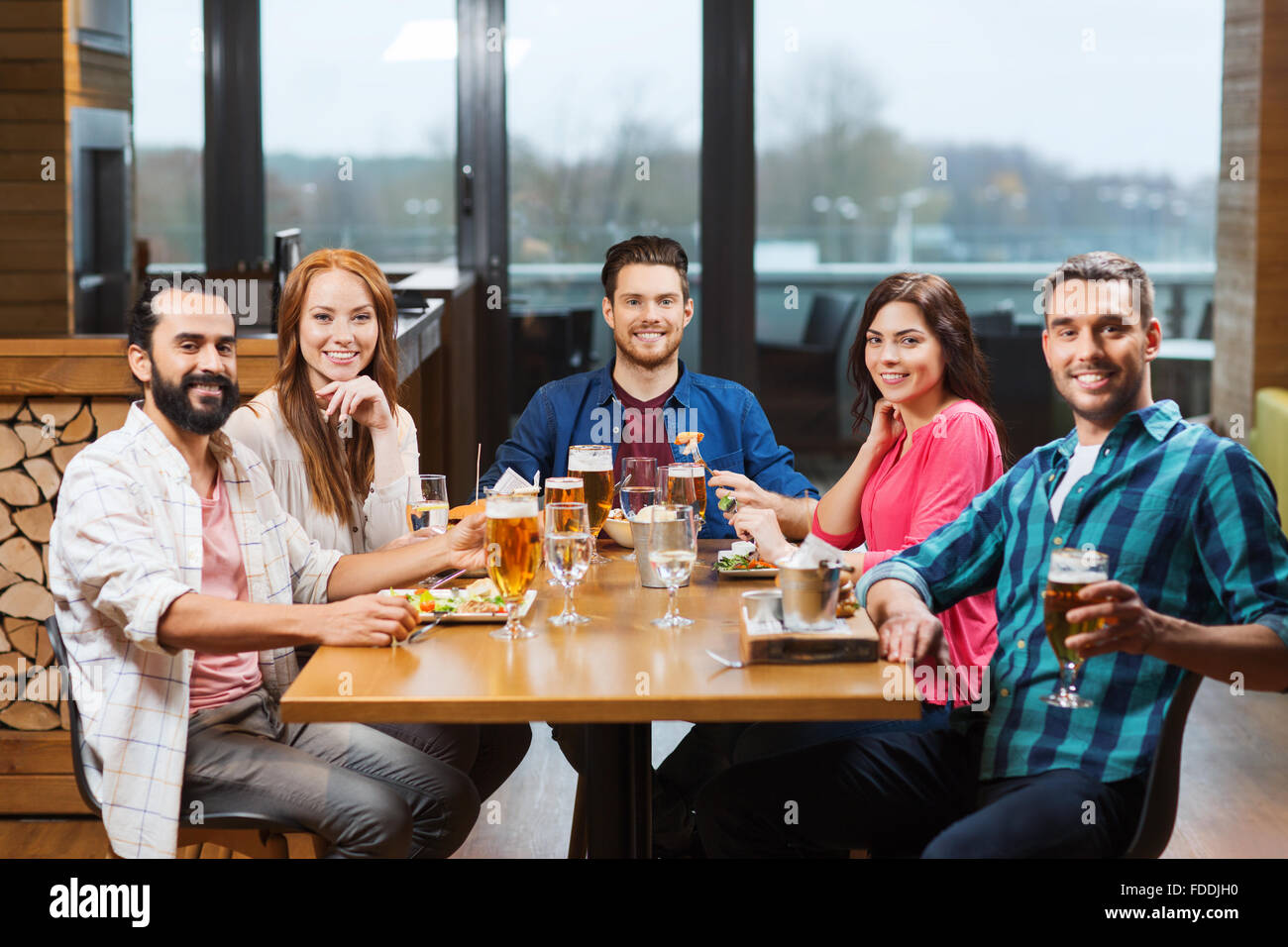 friends dining and drinking beer at restaurant Stock Photo - Alamy