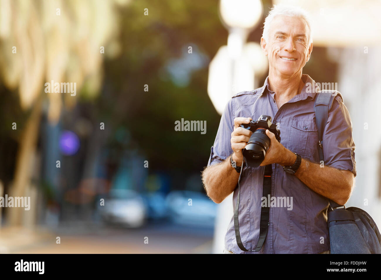 Senior man with camera in city Stock Photo - Alamy