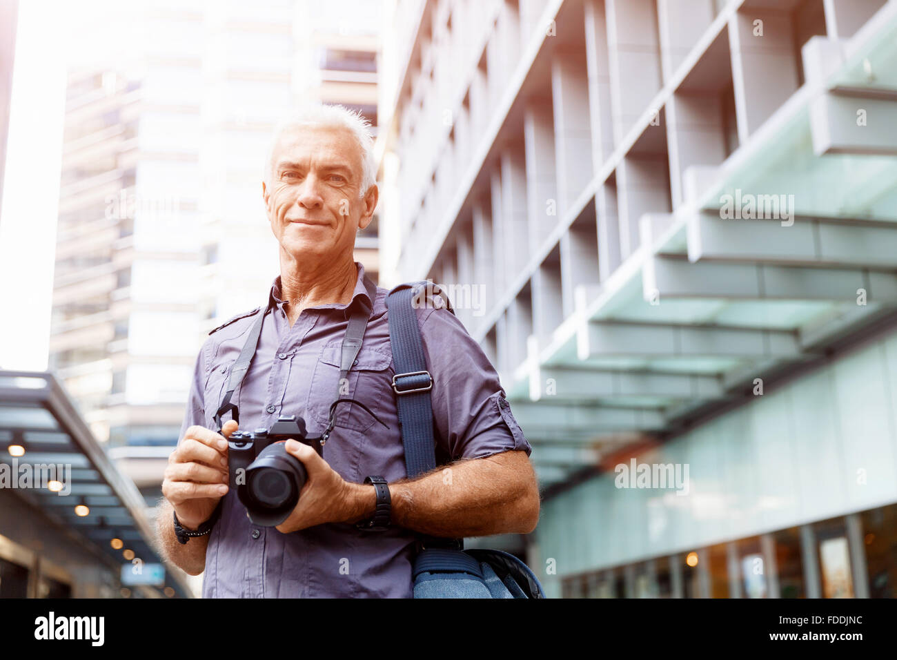 Senior man with camera in city Stock Photo - Alamy