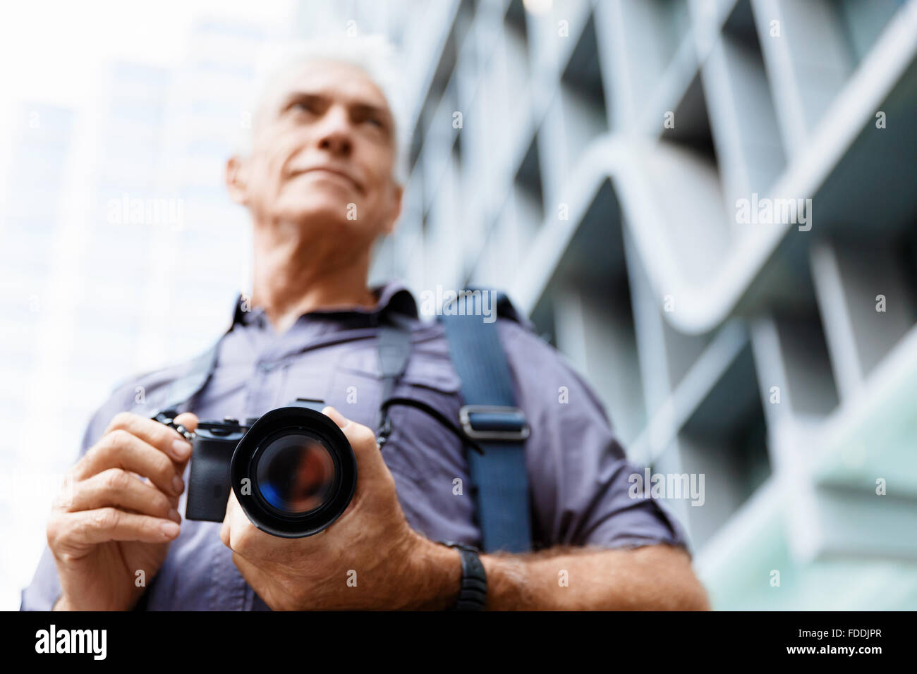 Senior man with camera in city Stock Photo - Alamy