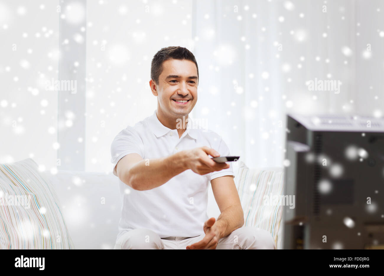 smiling man with remote control watching tv Stock Photo - Alamy