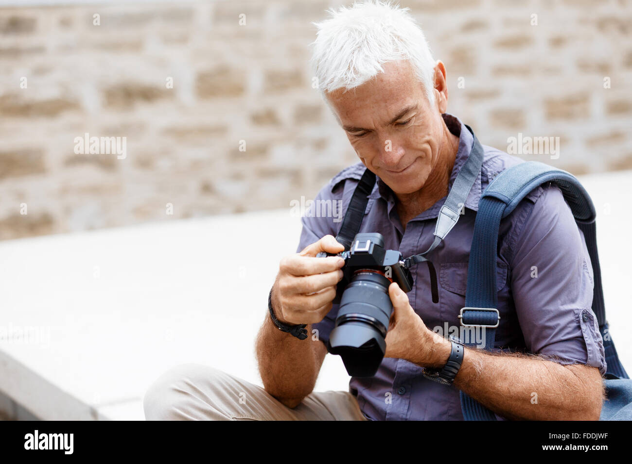 Senior man with camera in city Stock Photo - Alamy