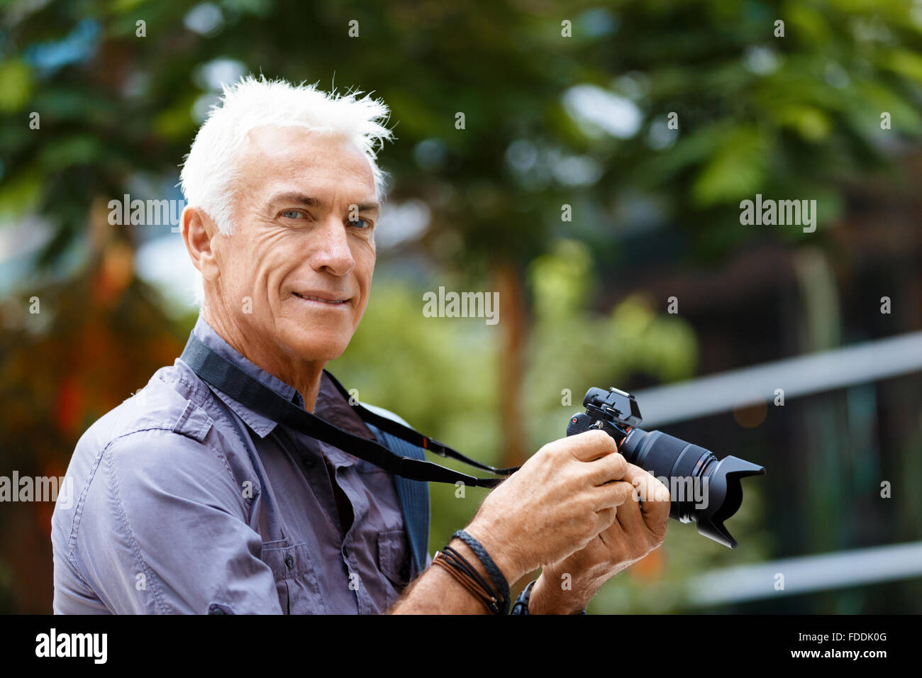 Senior man with camera in city Stock Photo - Alamy