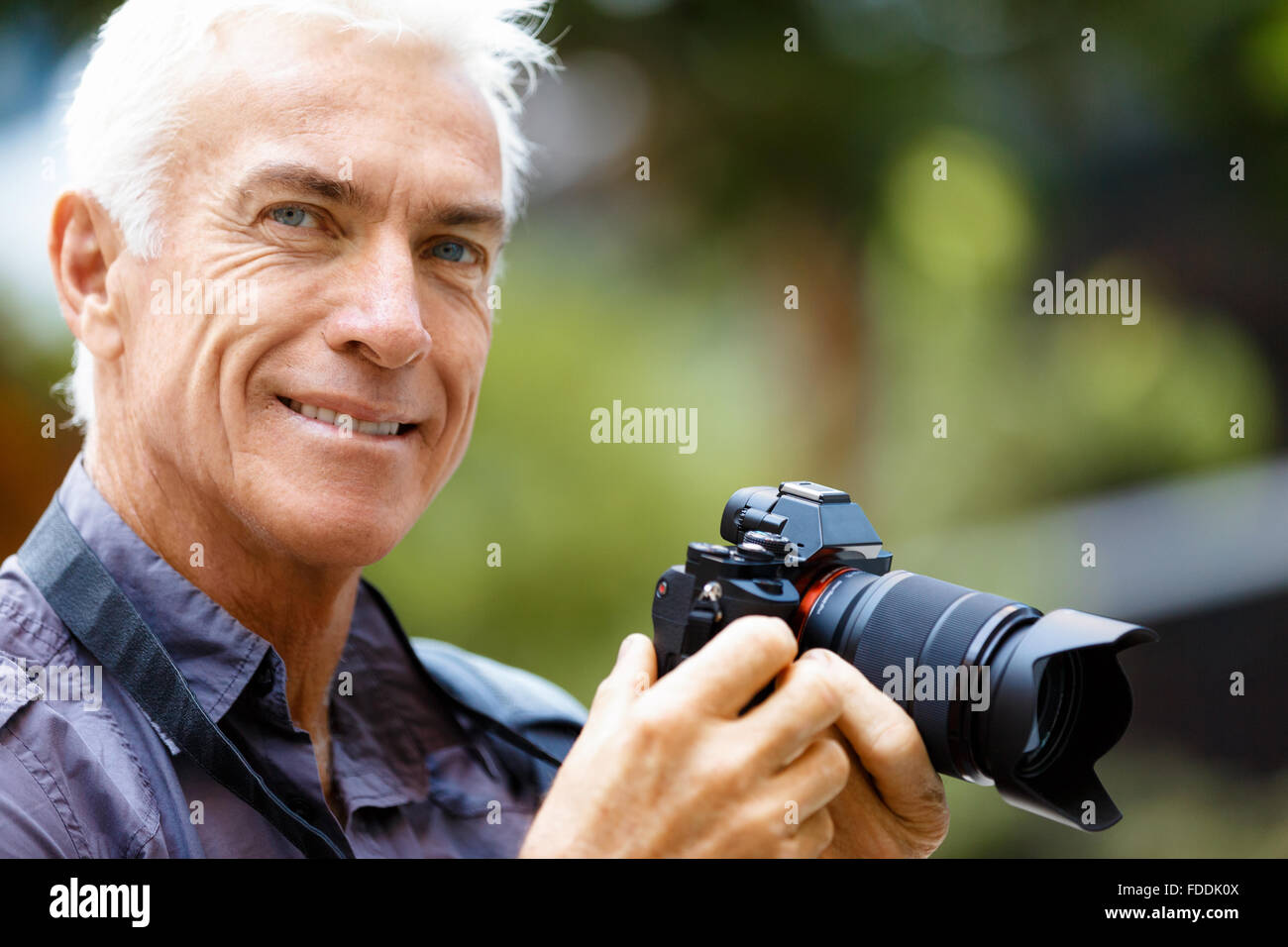 Senior man with camera in city Stock Photo - Alamy