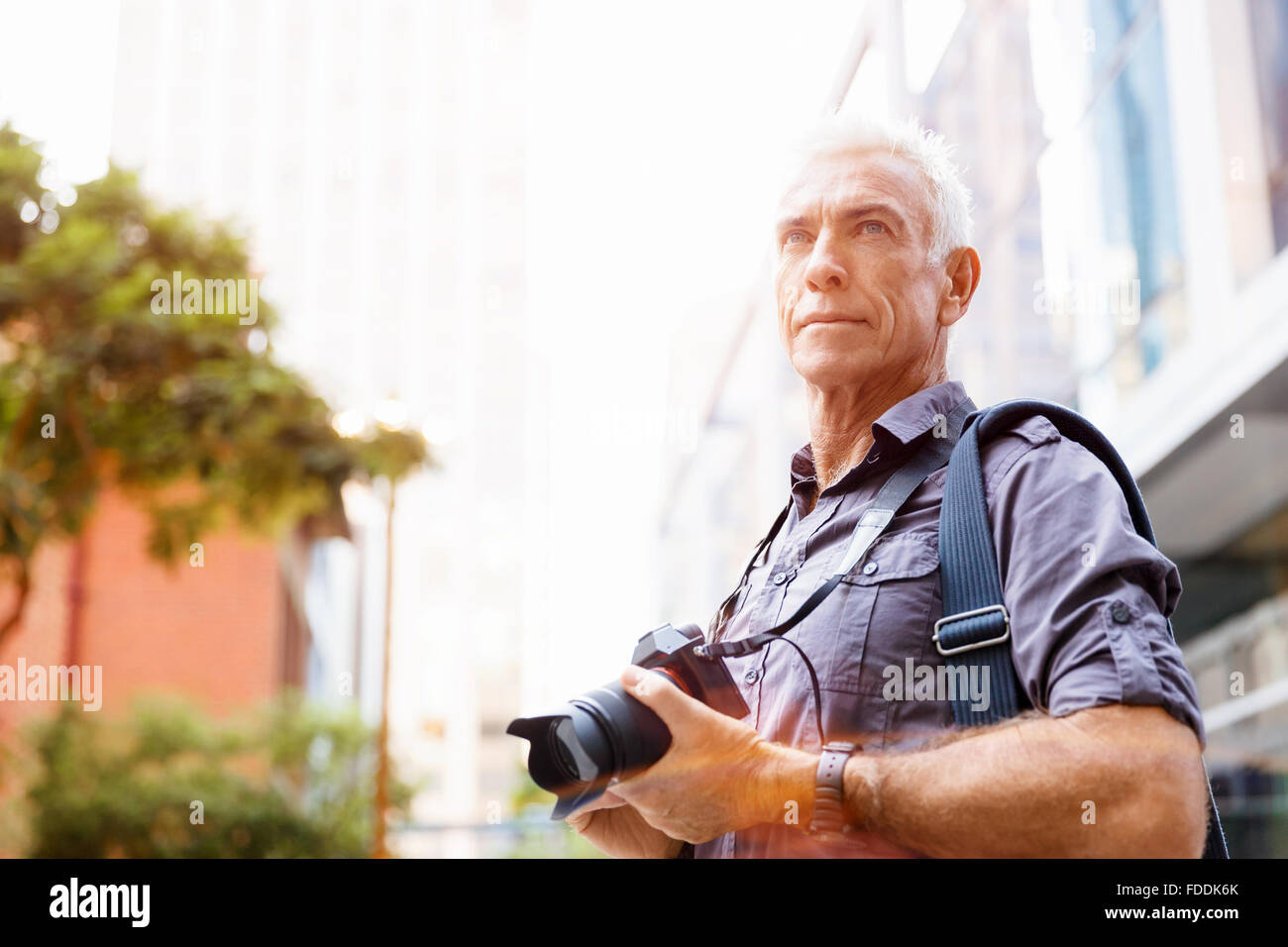 Senior man with camera in city Stock Photo - Alamy