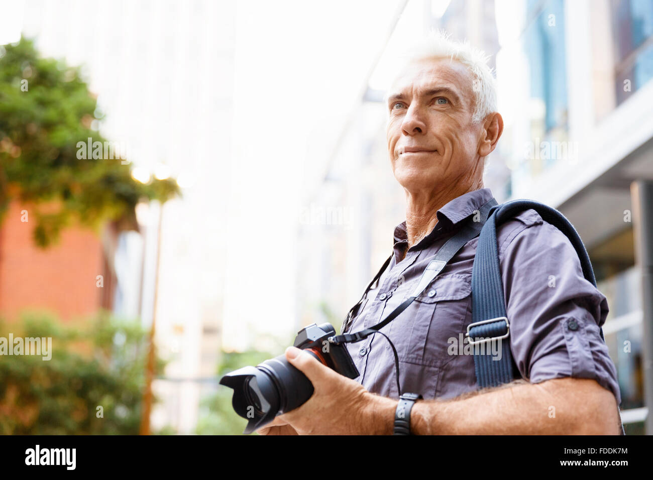 Senior man with camera in city Stock Photo - Alamy