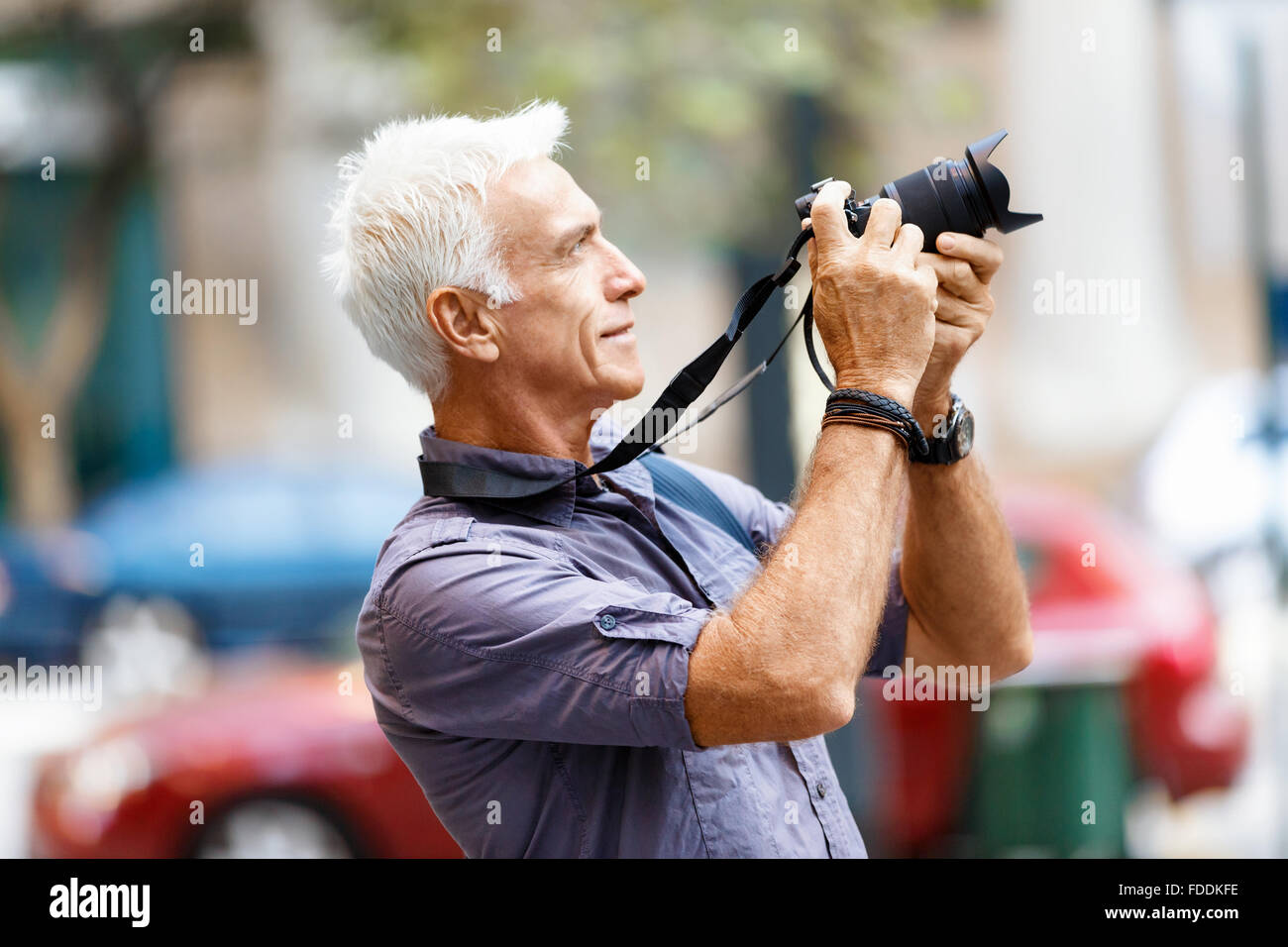 Senior man with camera in city Stock Photo - Alamy